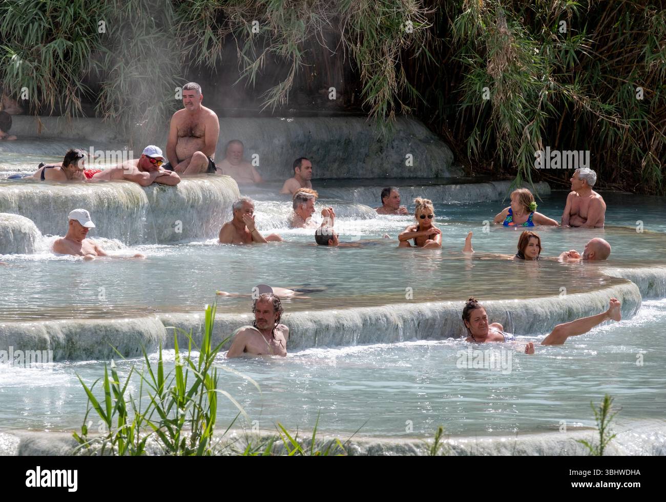 People bathe in the natural bubbling thermal waters hot springs in Saturnia, Maremma, southern ...