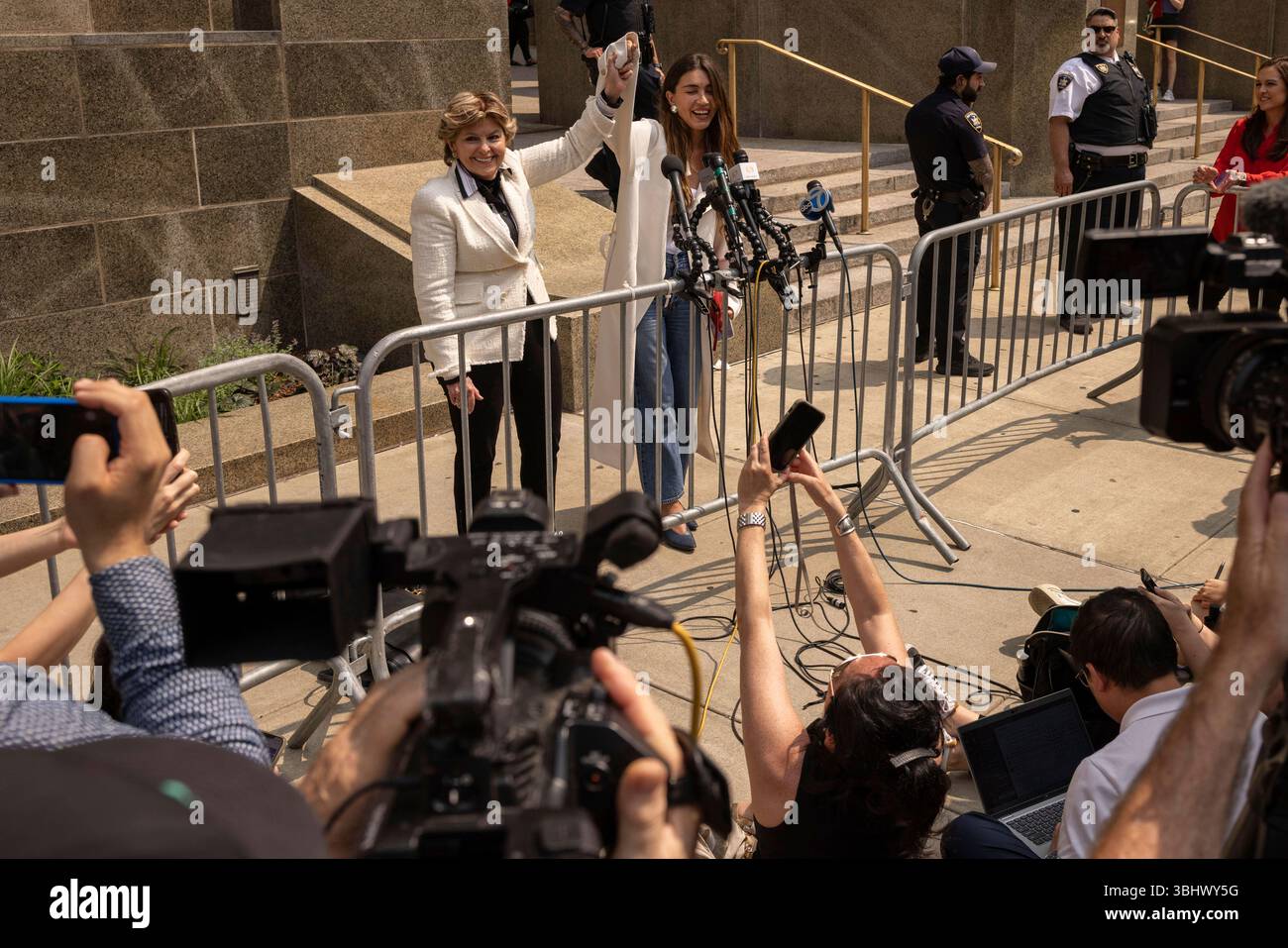 Attorney Gloria Allred, left, and Mimi Haley, right, raise their fists ...