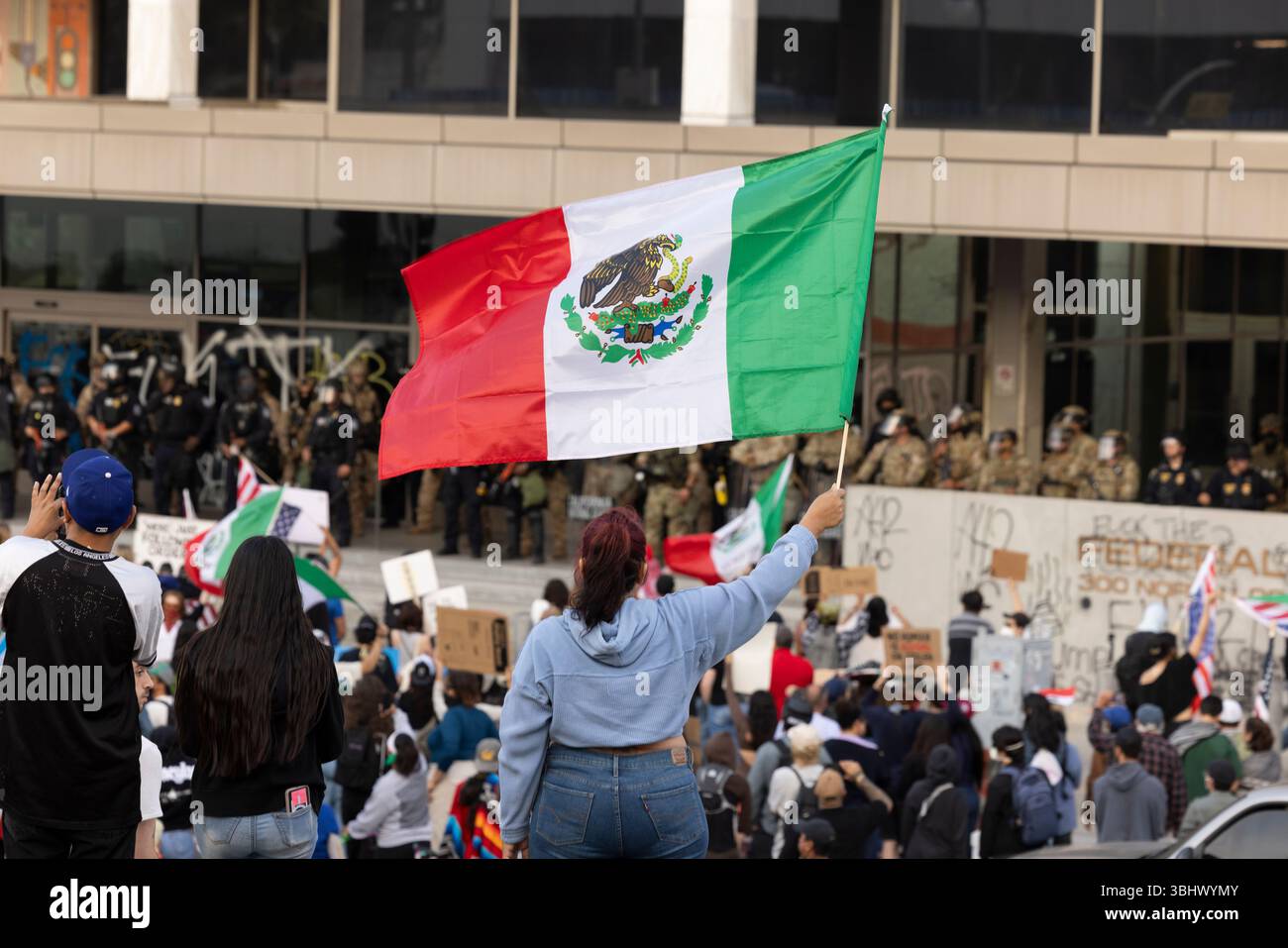 Los Angeles, California, USA - June 10, 2025: People hold Mexican flags ...