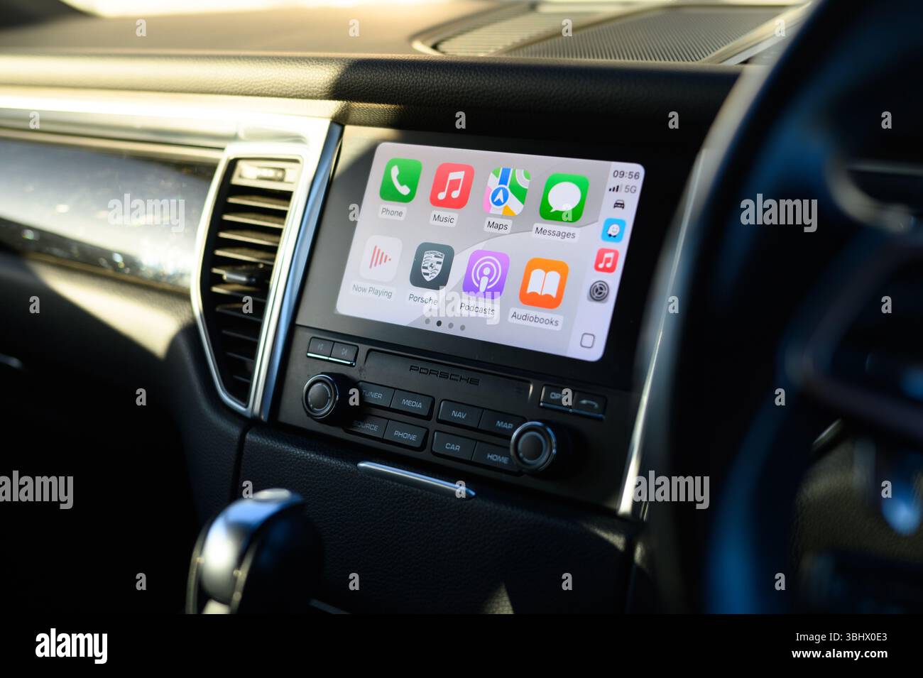 This image captures a modern car dashboard with Apple CarPlay active on ...