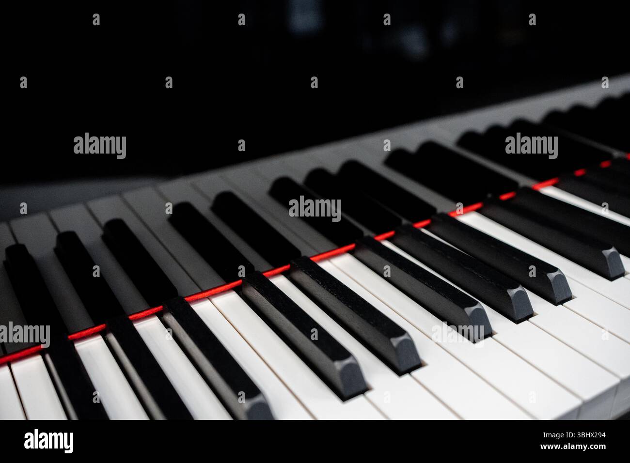 Close-up of piano keys with a red thread running through them ...