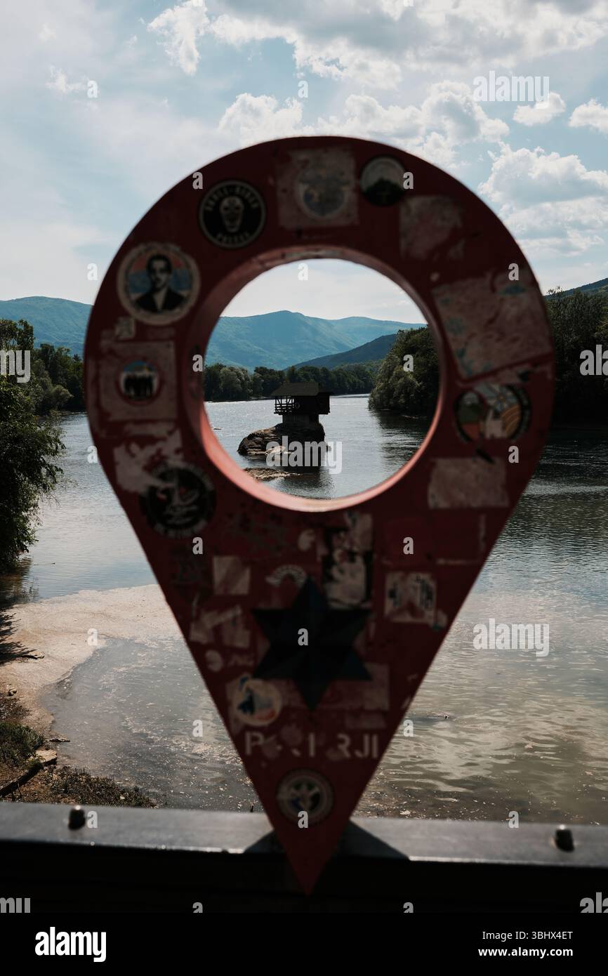 Iconic view of the Drina River house framed through a large red pin sculpture in Tara National ...
