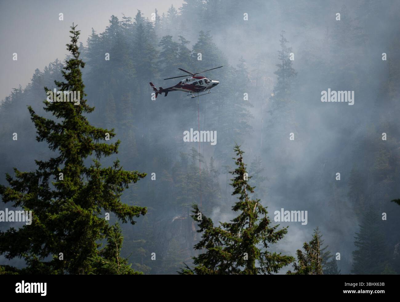 A helicopter drops water on the Dryden Creek Wildfire, just north of ...