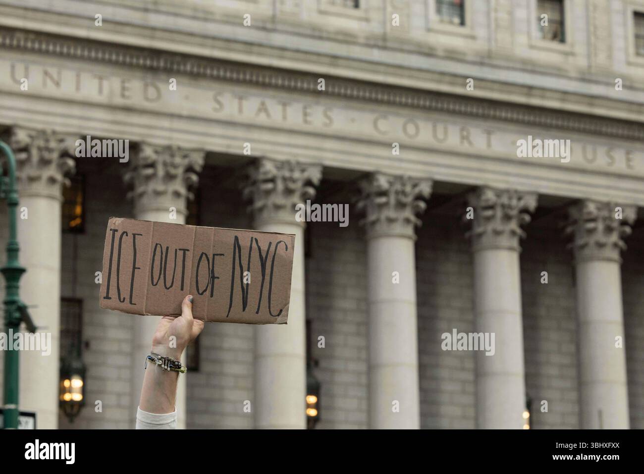A demonstrator raises a sign during a protest against deportation by ...