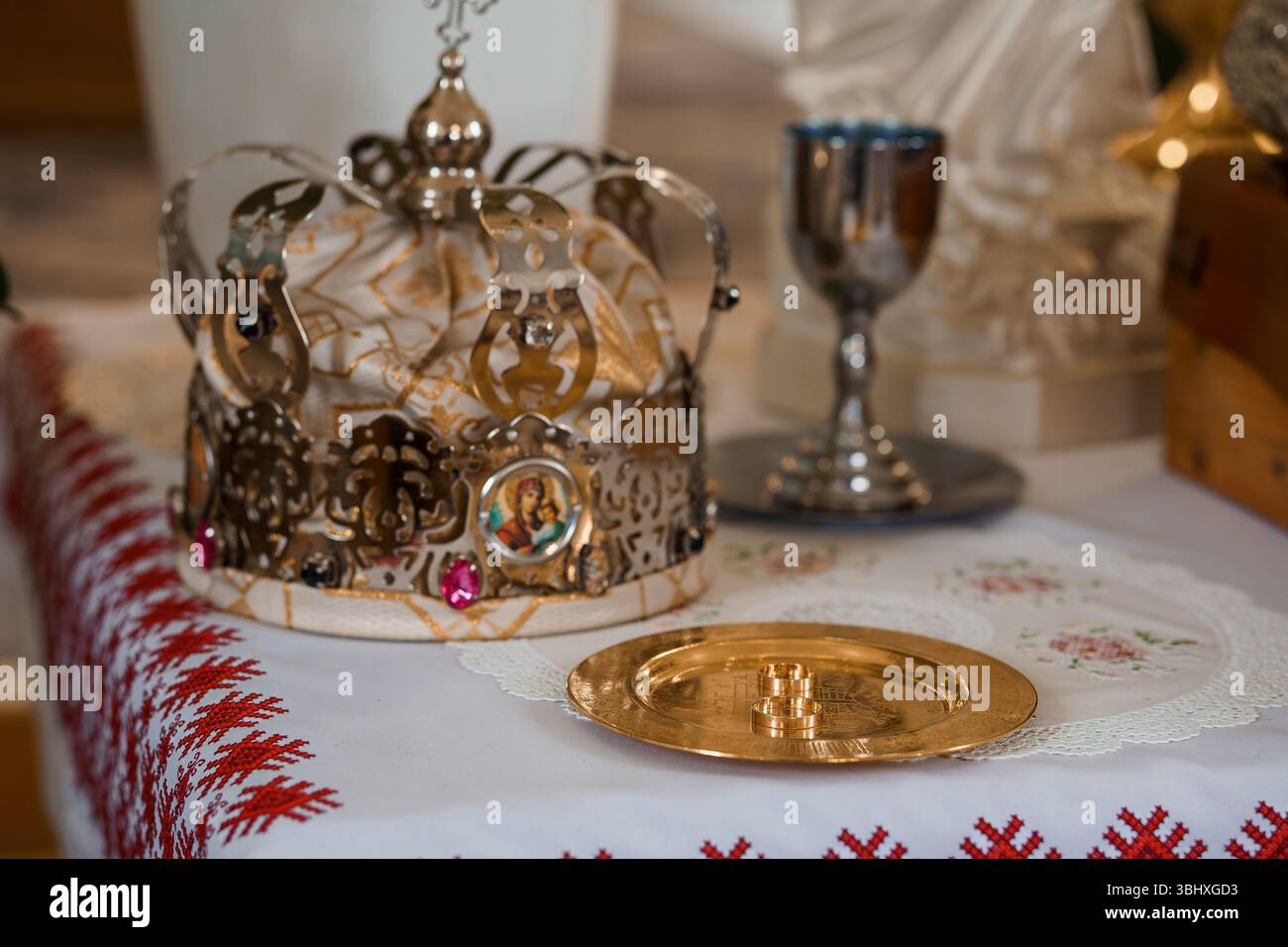 A close-up showcases an ornate golden crown alongside a chalice and ...