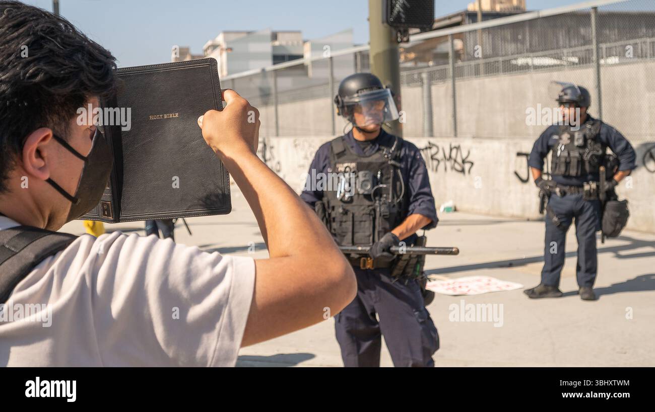Los Angeles, USA – June 8, 2025: Man holding an open Bible in front of ...