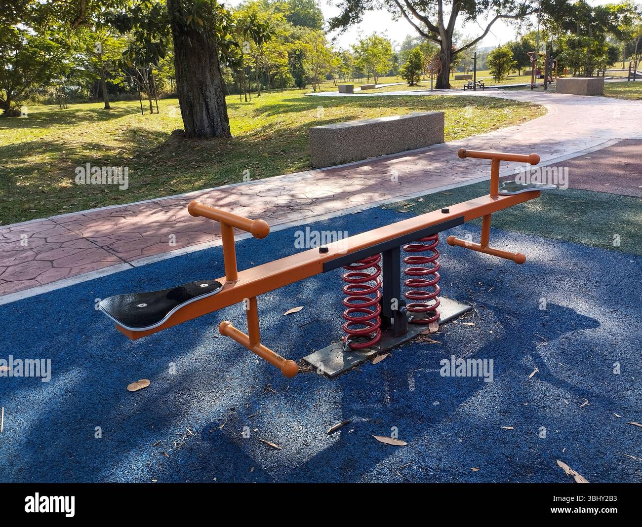 Colorful Seesaw in a Sunny Park Playground with Trees and Pathways ...