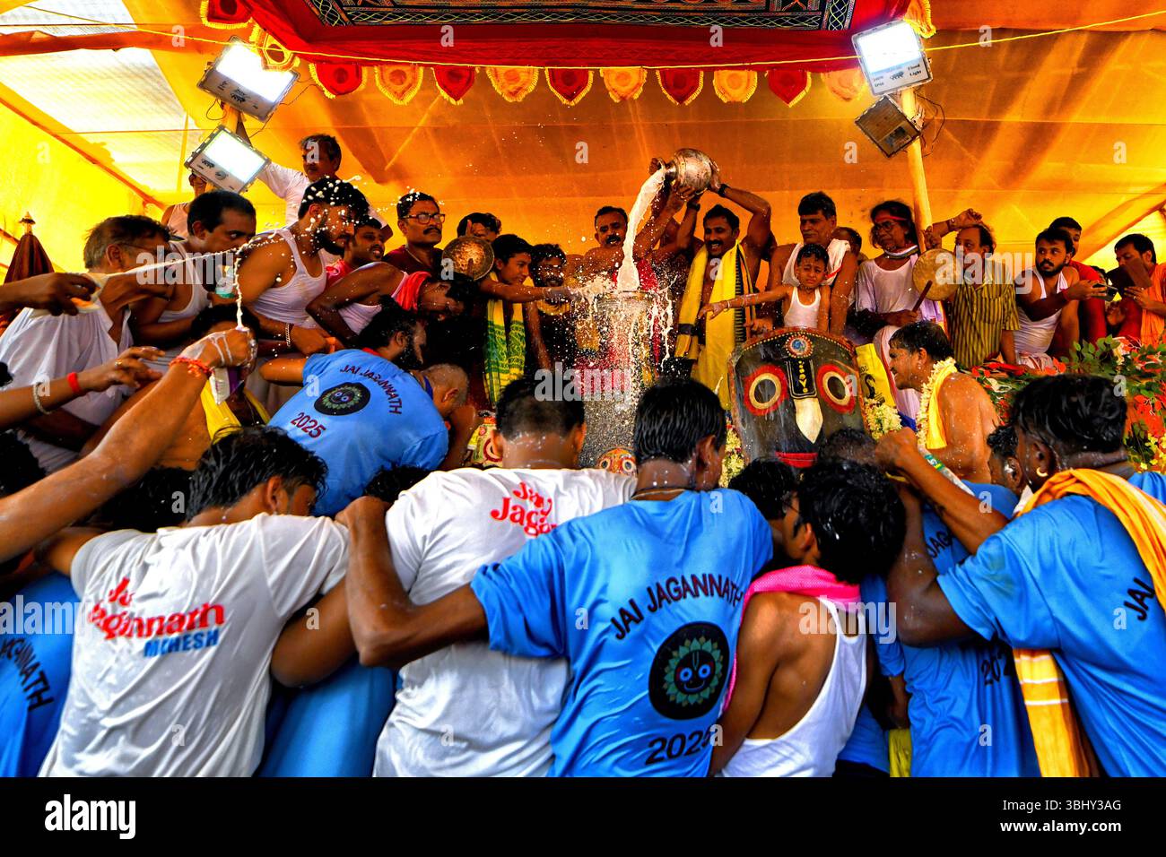 Hindu monks and devotees perform a ritual of bathing Hindu deity idols ...