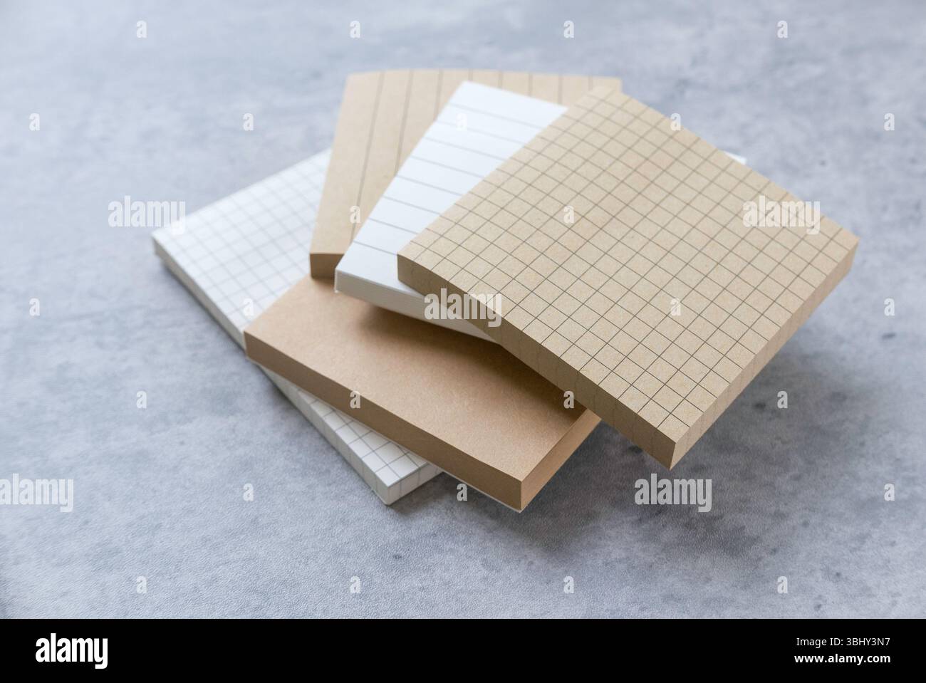 Variety of Paper Types: Lined, Grid, and Plain Sheets on a Gray Surface ...