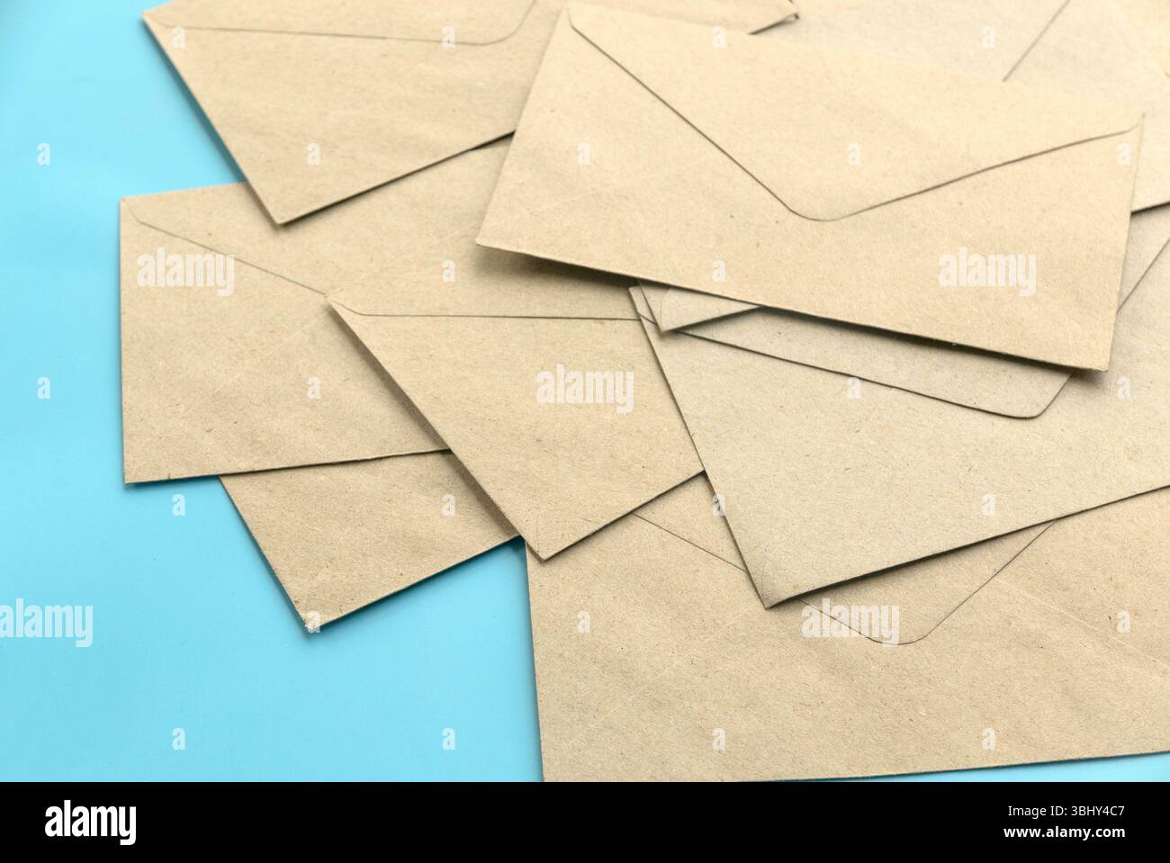 A stack of brown envelopes on blue background with copy space Stock ...