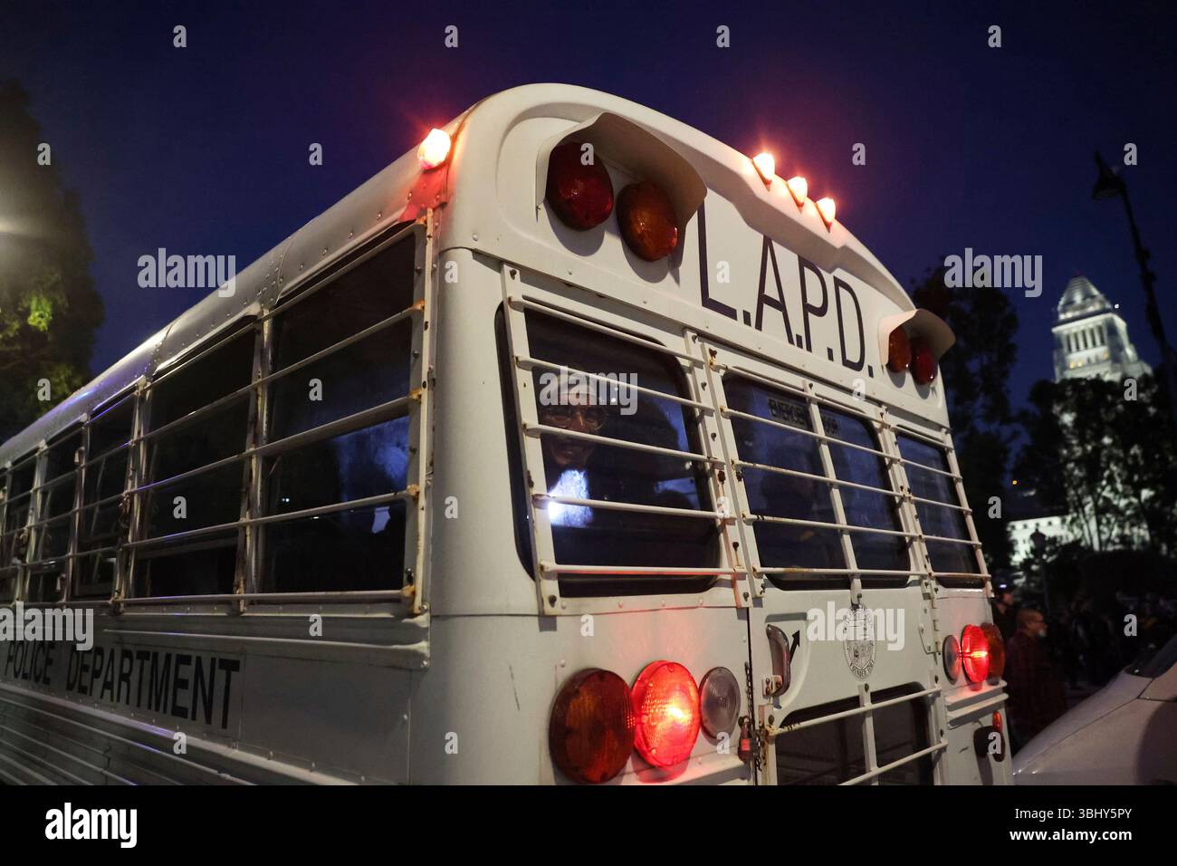A person smiles on a Los Angeles Police Department bus after being ...