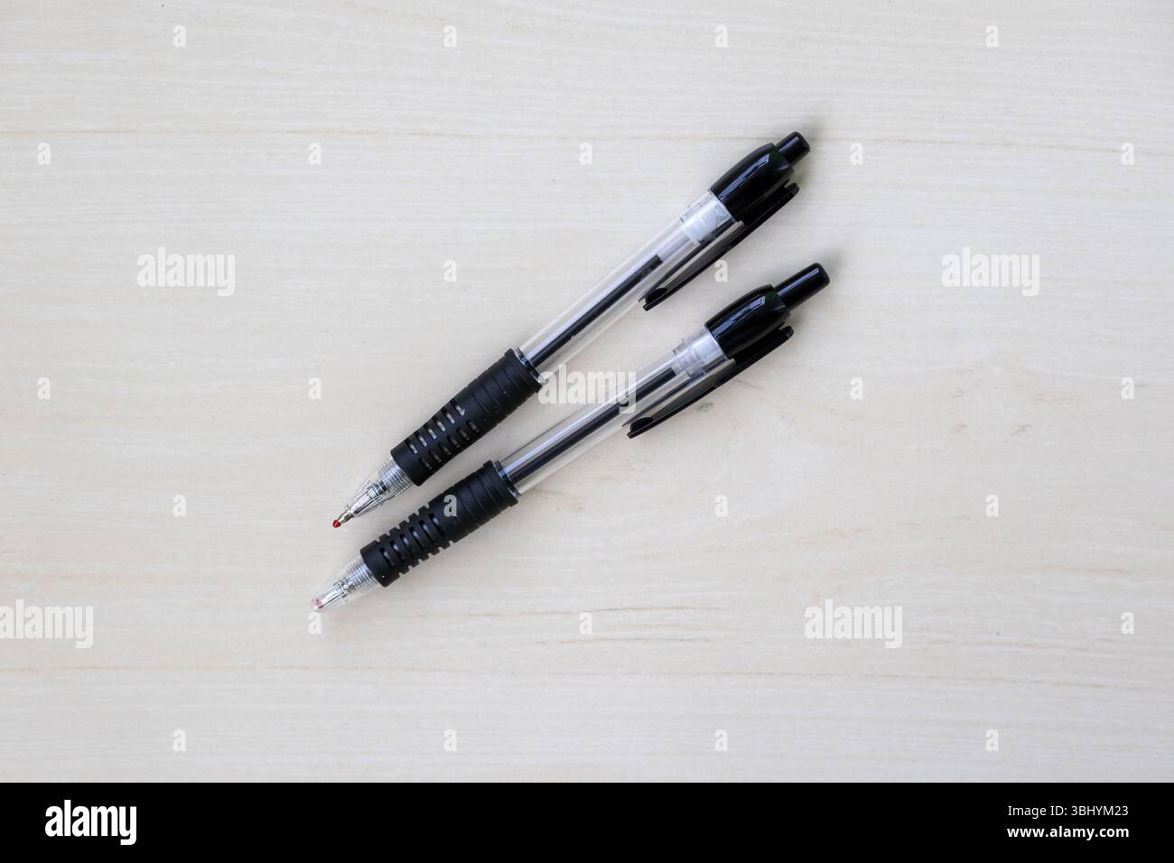 Two ballpoint pens on a light wooden surface. A very important tool for ...