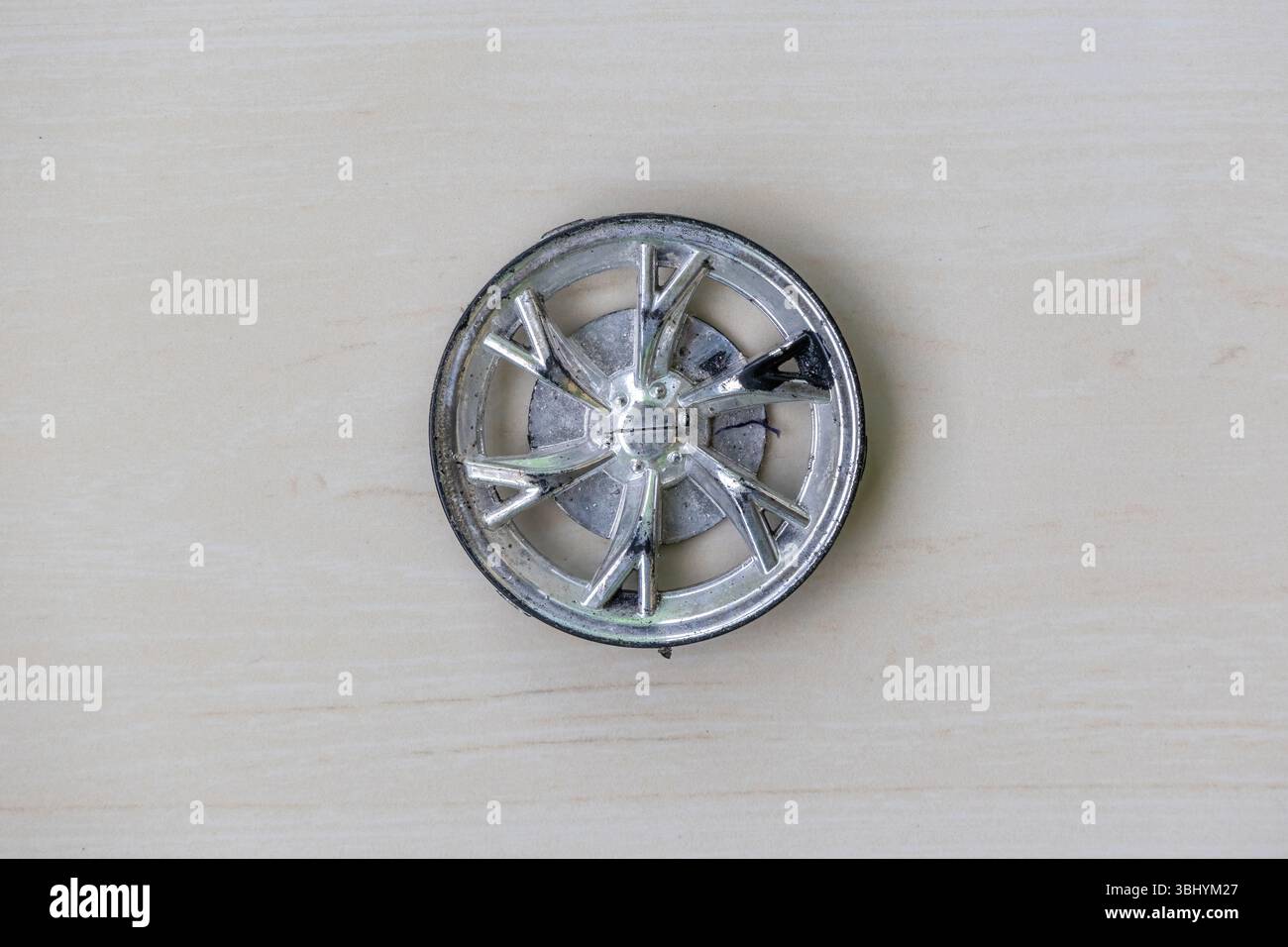 Broken plastic toy car wheel part on a wooden surface. Top view Stock ...