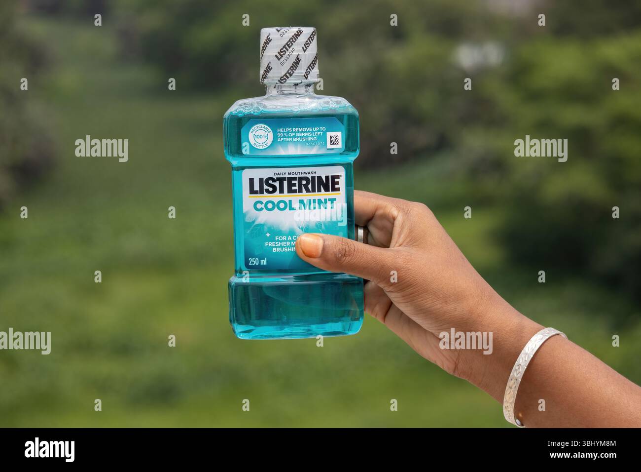 Listerine Cool Mint 250ml mouthwash in female hand, green nature ...