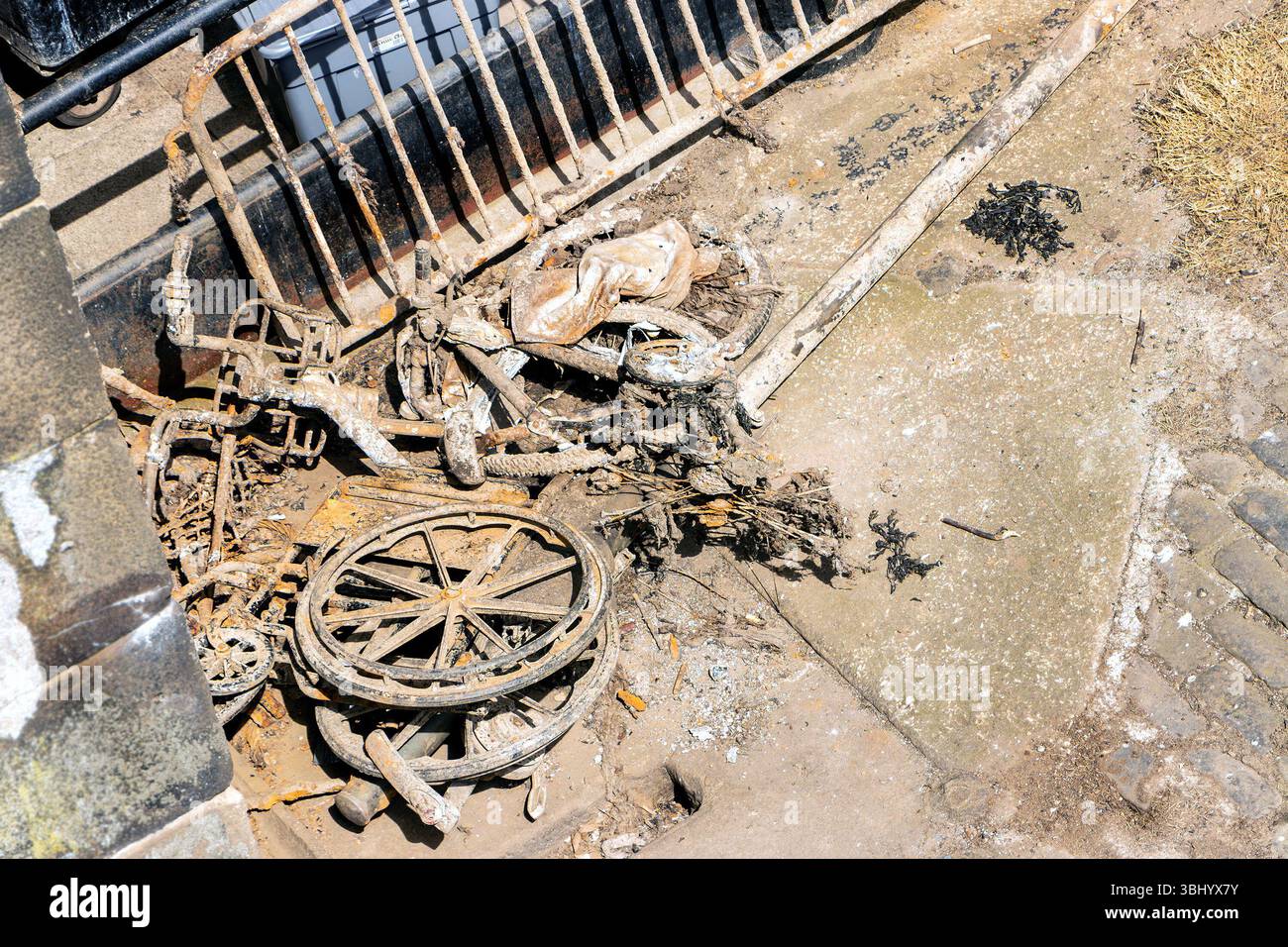 Rusty and abandoned bicycle and wheelchair in urban environment, lying ...