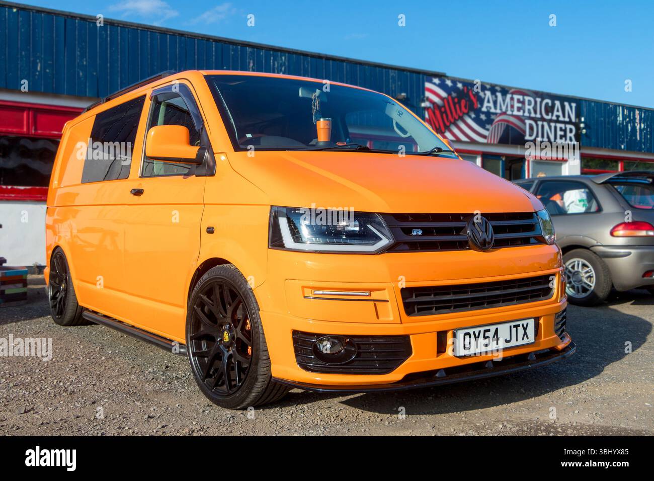 Bright orange modified Volkswagen VW transporter T5 camper van parked ...