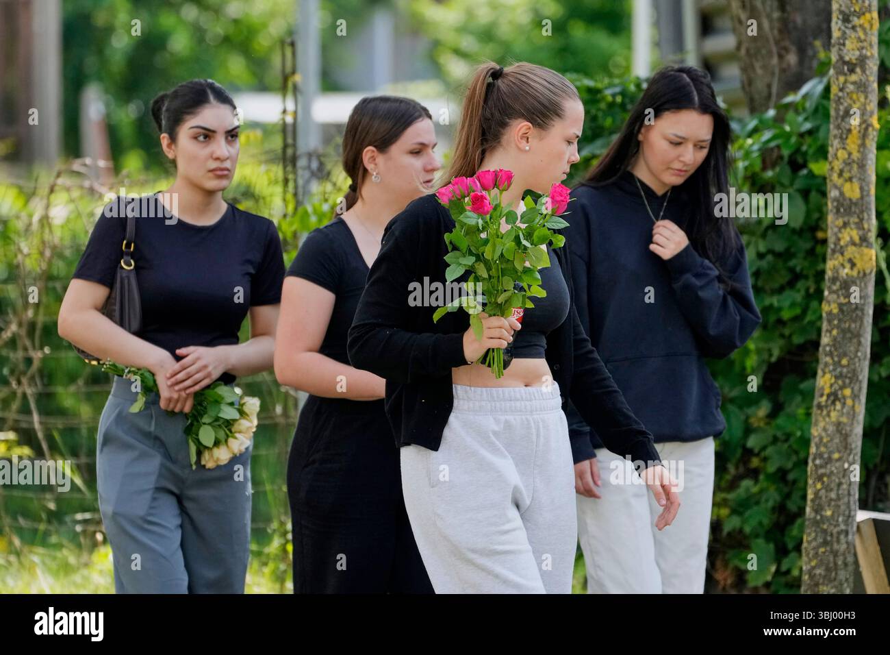 Women with flowers arrive at a school where a former student opened ...