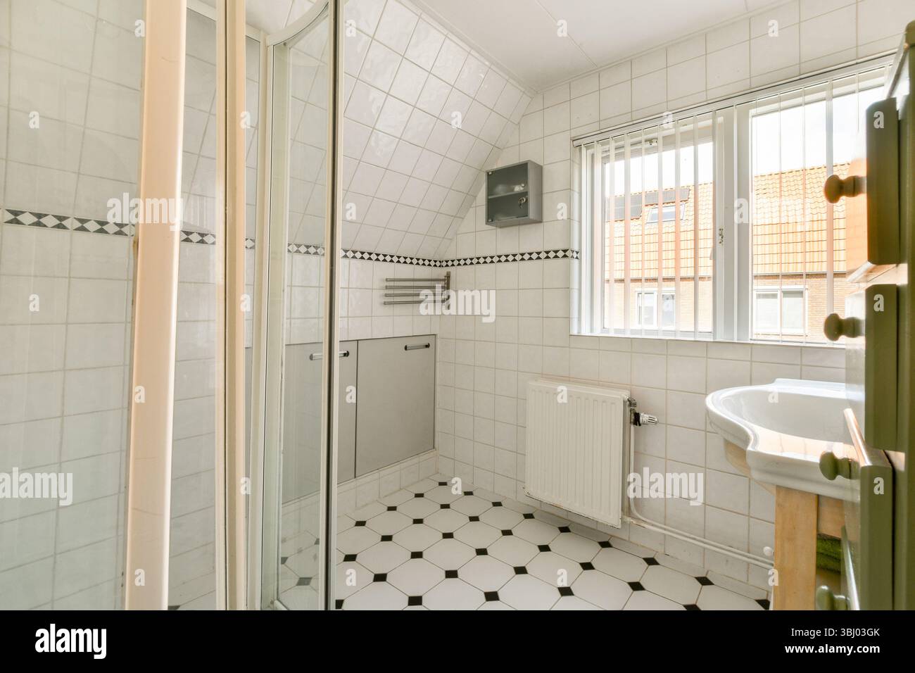 A bright, modern bathroom featuring elegant tile work, a shower area ...