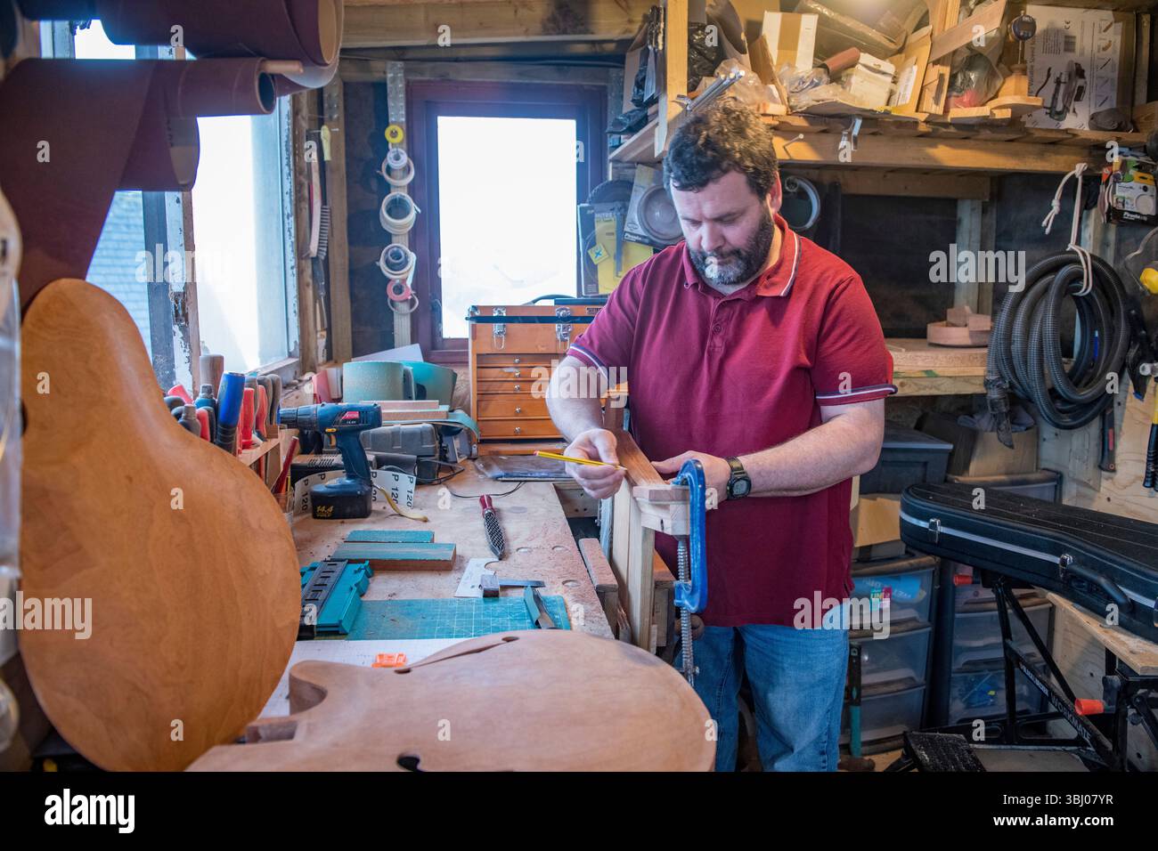 Instrument maker and repairer in Scalloway, Shetland, carefully ...