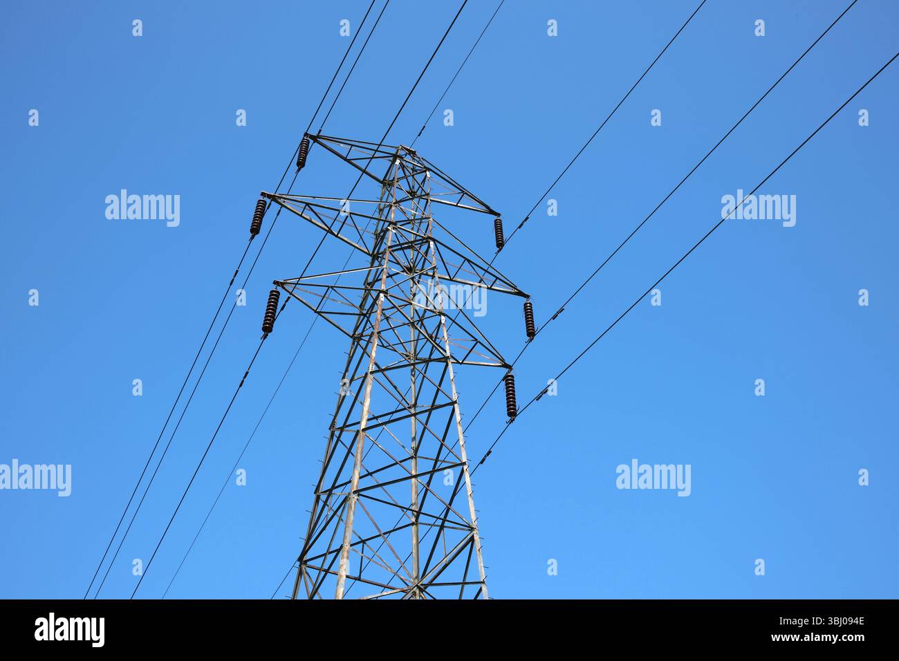 Electricity pylons against blue sky Stock Photo - Alamy