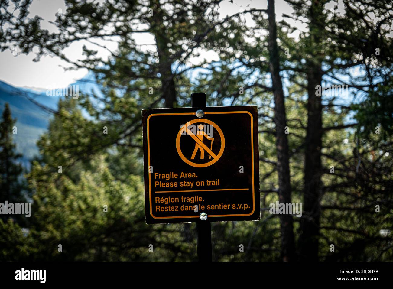Warning sign Fragile area on the hiking trail in English and French ...