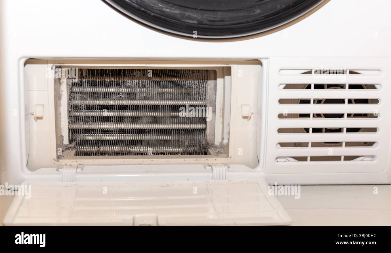 lint-covered condenser coil inside a clothes dryer, showing heavy dust ...