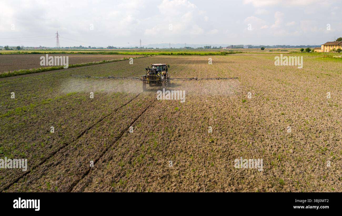 Tractor spraying herbicide in rice field during spring in Piedmont ...