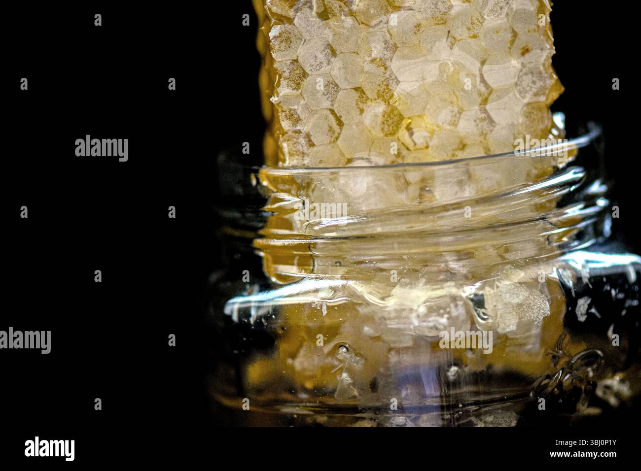 Macro details of honeycomb in a glass jar Stock Photo - Alamy