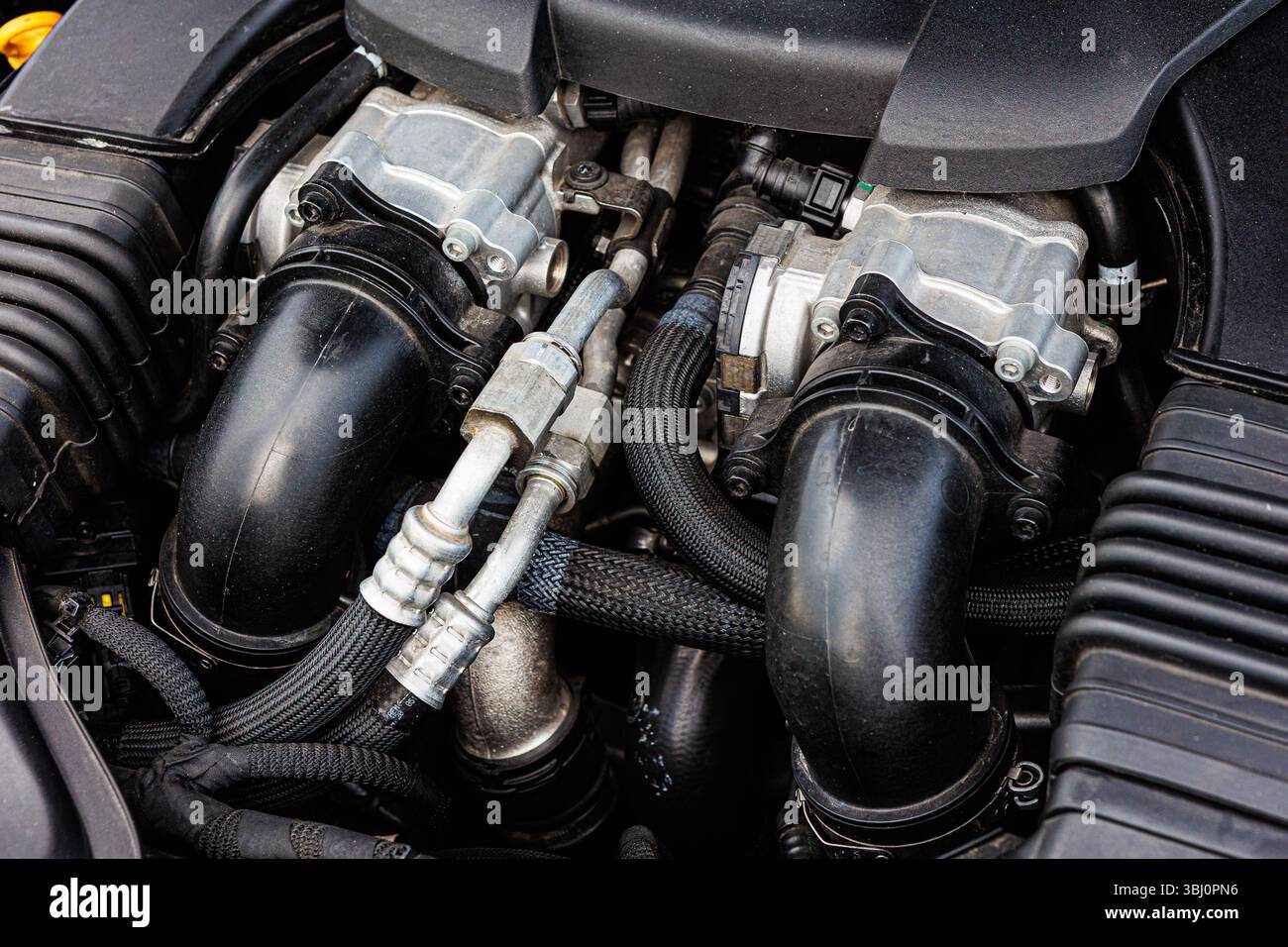 Modern car engine bay, highlighting various mechanical components ...