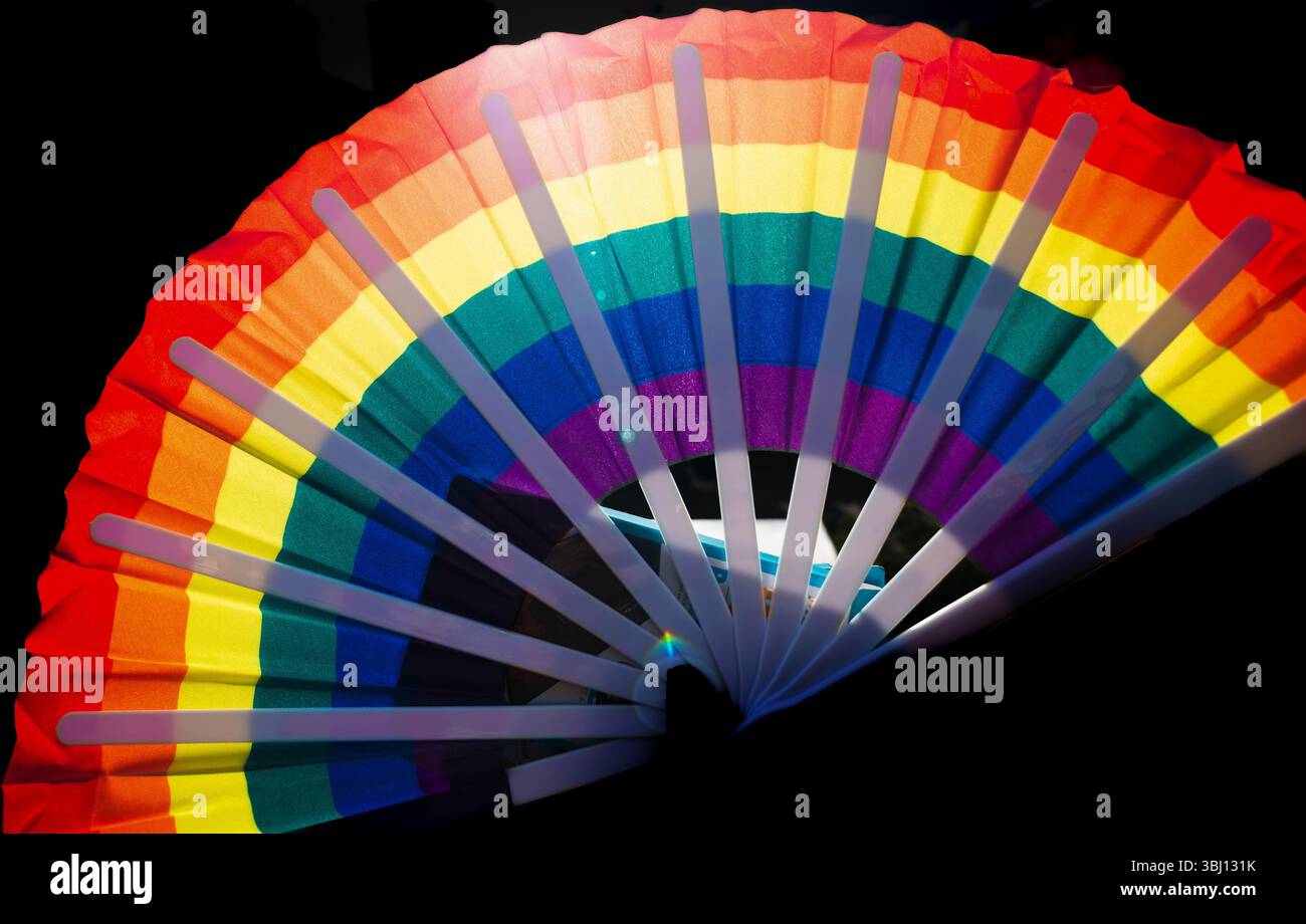 A colorful fan opened to ventilate. Intense heat, object accessory ...