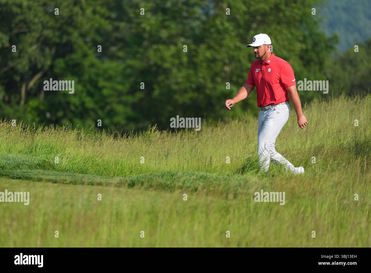 Bryson DeChambeau walks through tall grass on the fourth hole during ...