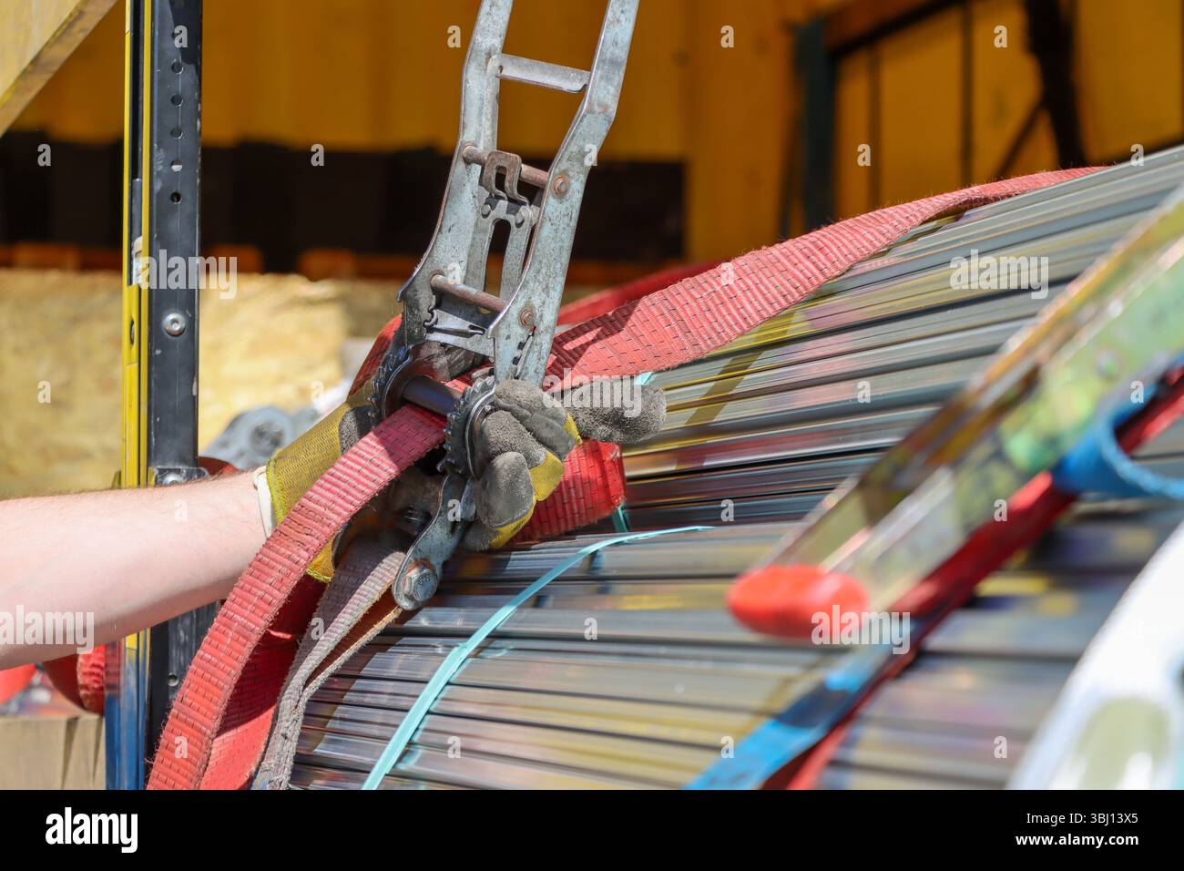 a man secures a load with a lashing strap Stock Photo - Alamy