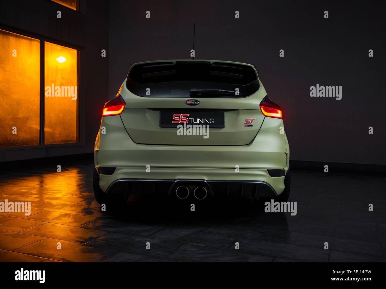 Olive Focus ST in dark garage. Rear view of satin green Ford hatchback ...
