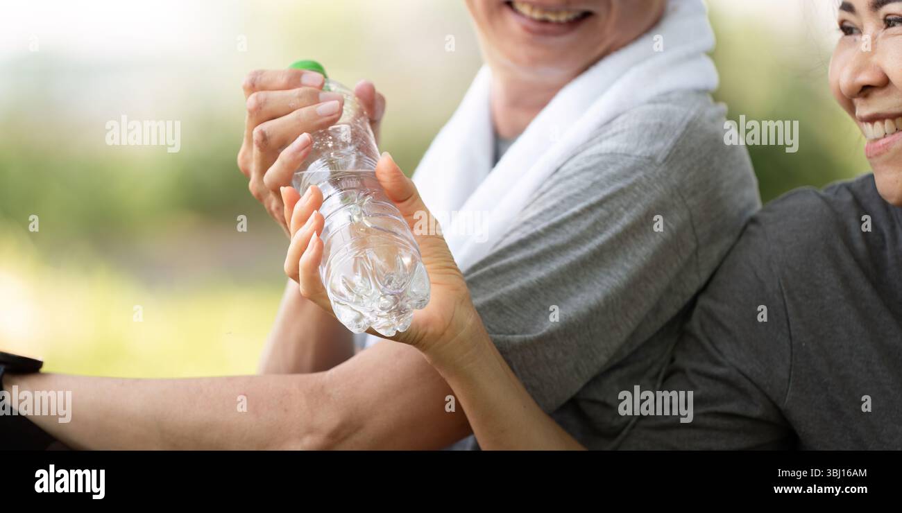 Couple sharing water and smiles during fitness session Stock Photo - Alamy
