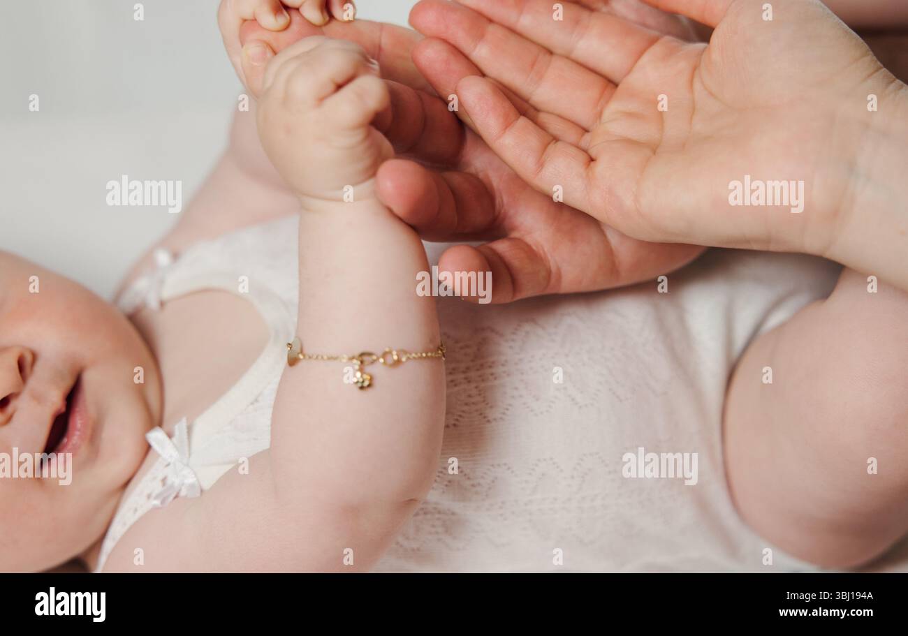 Joyful baby bonding with mother through gentle touch Stock Photo - Alamy