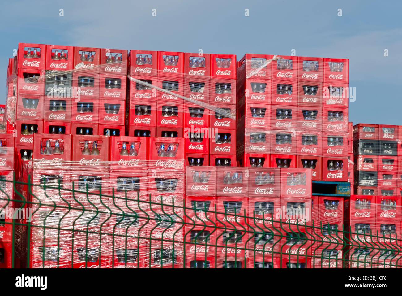 Row of stacked crates of thousands of empty Coca-Cola bottles on ...