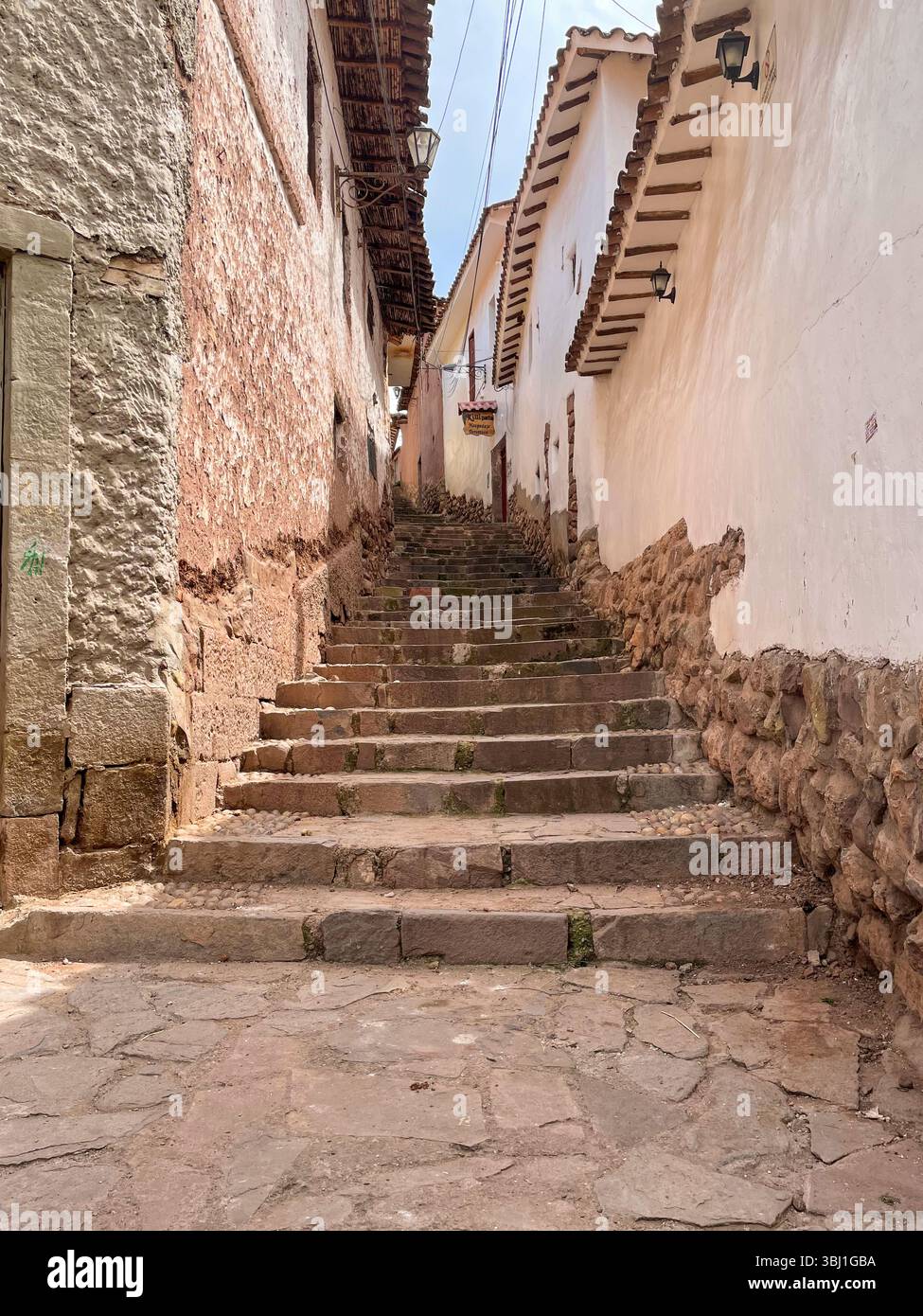 A narrow alleyway with a stone staircase leading up to a building. The ...