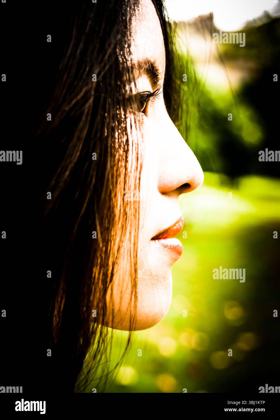 A side profile of a woman's face, with her hair partially obscuring her ...