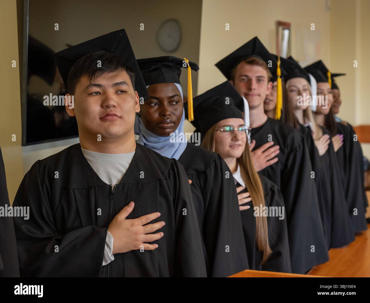 Graduates stand proudly ceremony hands hi-res stock photography and ...