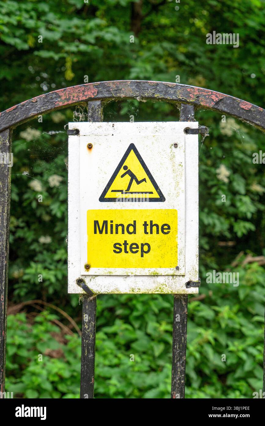 Mind the step sign on a metal gate close up Stock Photo - Alamy