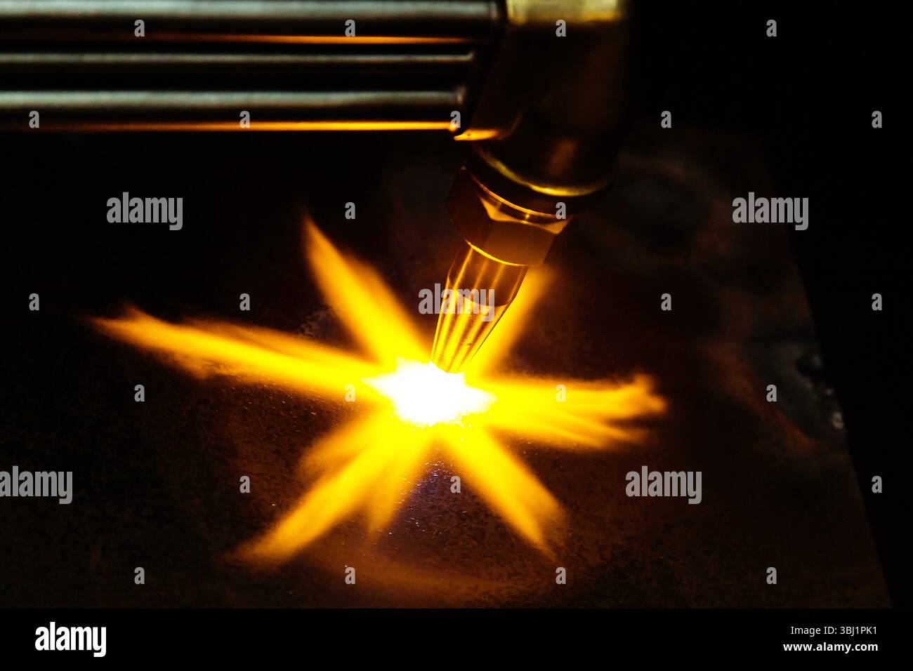 Gas cutting of metal. Gas cutter with copper nozzle with a stream of ...