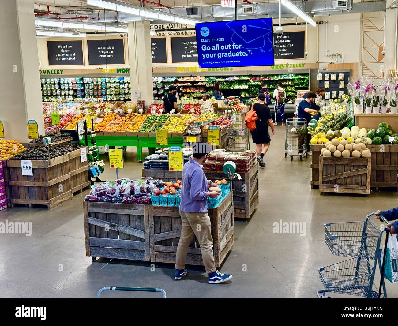 People shop in the produce area of an Whole Foods Store in downtown ...