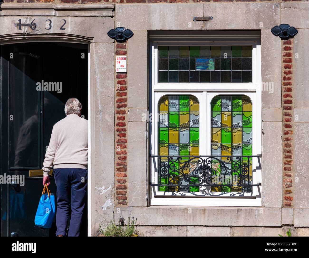 Maastricht, Netherlands - May 12, 2025: A person entering a historic ...
