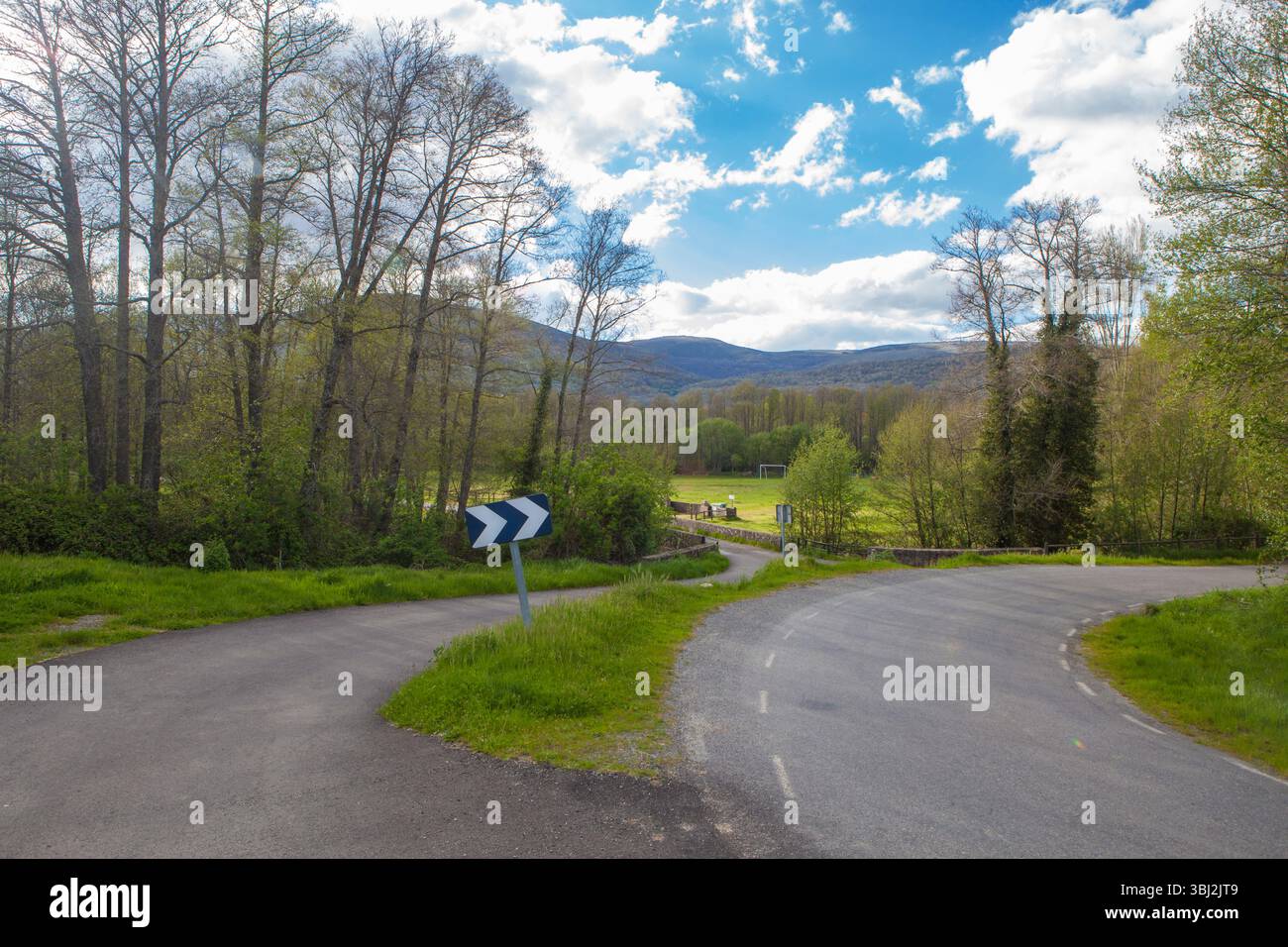 Sharp curve joint to fork to the left. Local country road Stock Photo ...