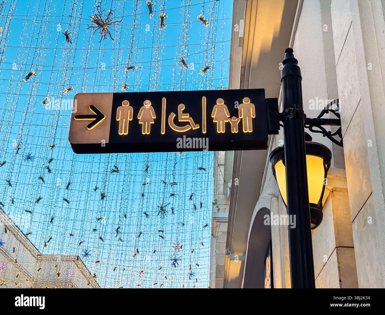 A directional sign points to restrooms for men, women, and accessible ...