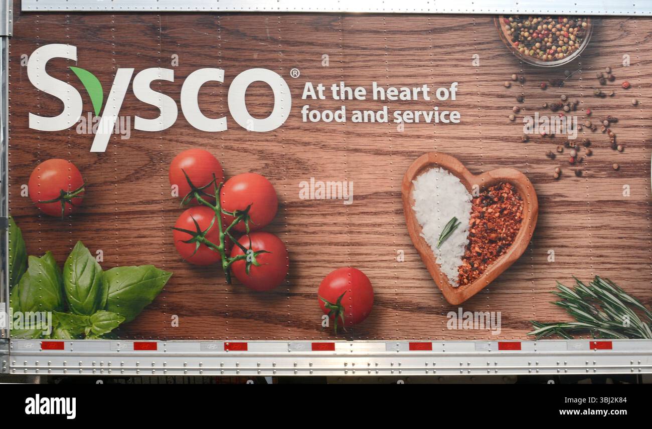 A Sysco wholesale food delivery truck and driver make a delivery to a ...