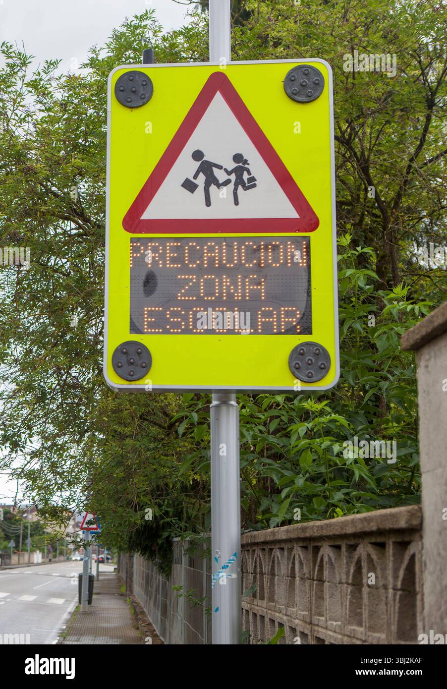 Signpost equipped with school warning message system. Spanish language ...