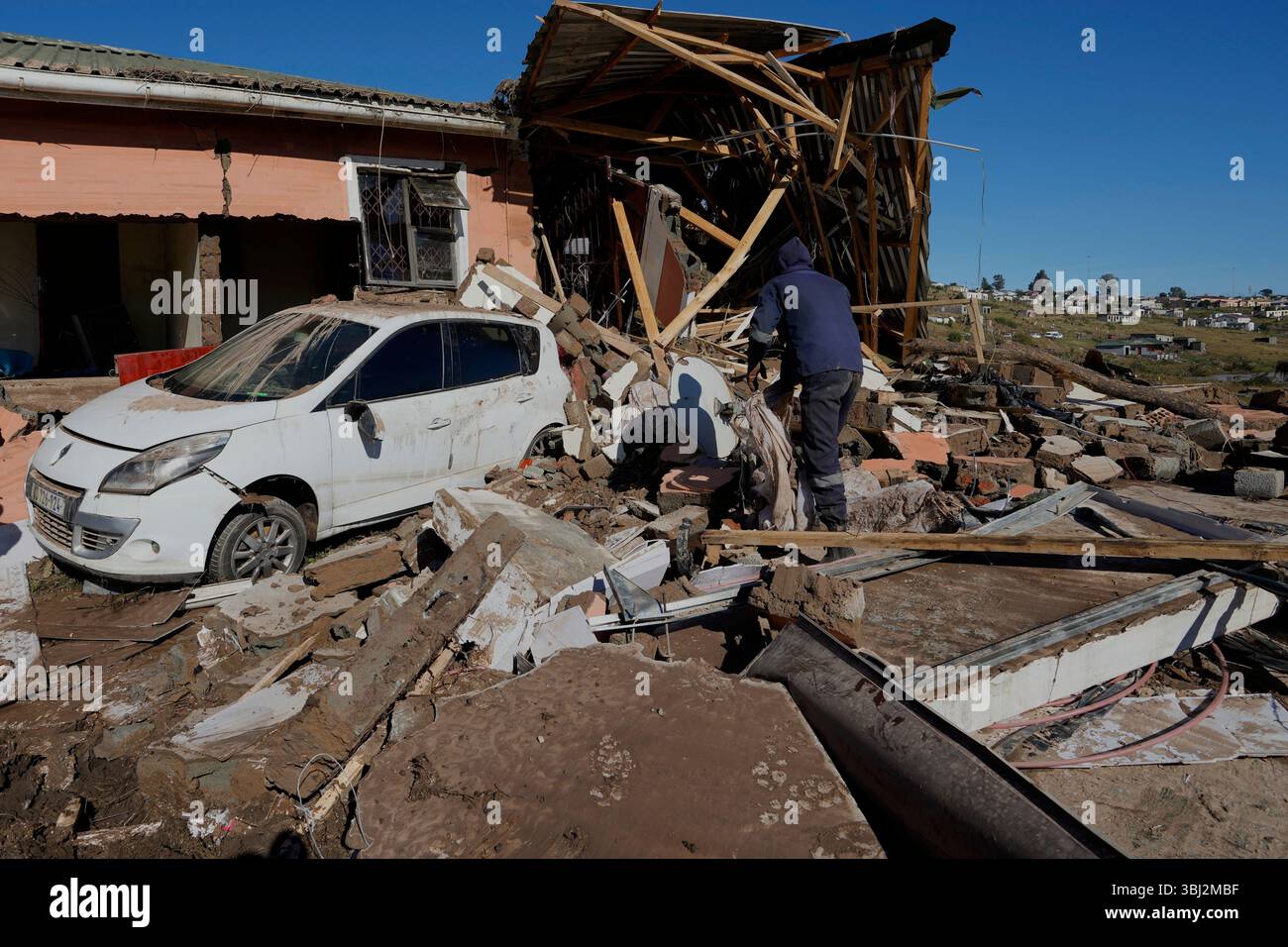 A resident looks through the remnants after floods swept through the ...