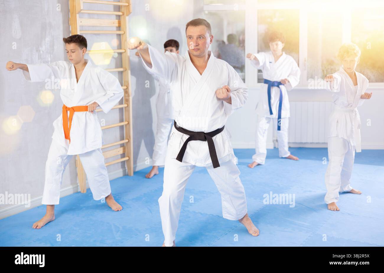 Karate instructor demonstrating kata sequence of movements to group of ...