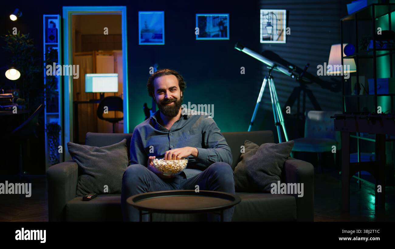 Man in apartment chocking on food while watching movie on TV and eating ...